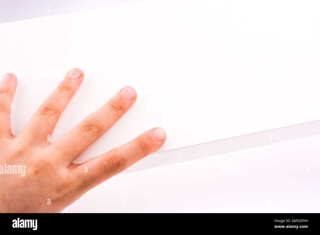 Hand holding a piece of paper on a white background Stock Photo - Alamy