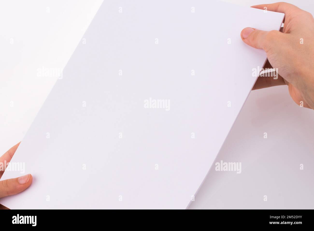Hand holding a white blank sheet of paper on a white background Stock ...