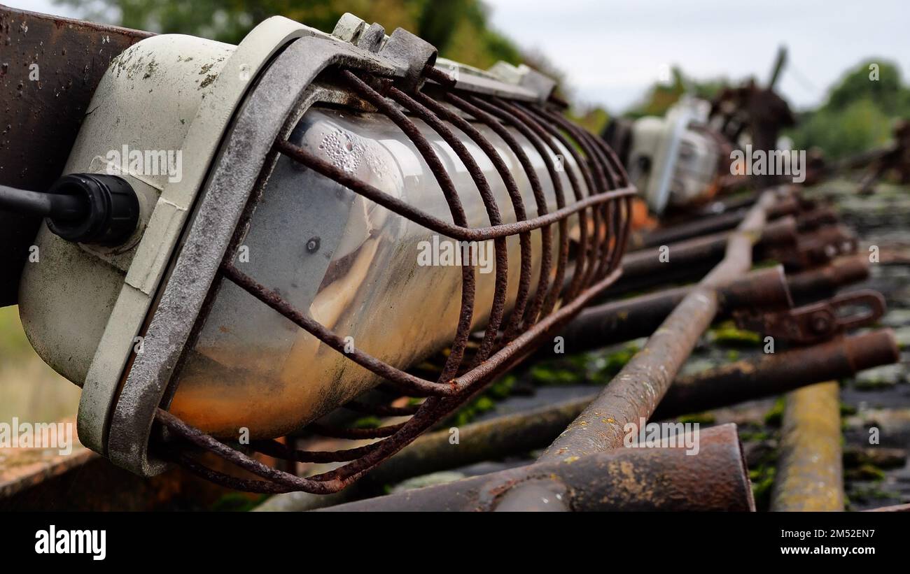 A shallow focus of a broken vintage Industrial metal lamp on the ground ...