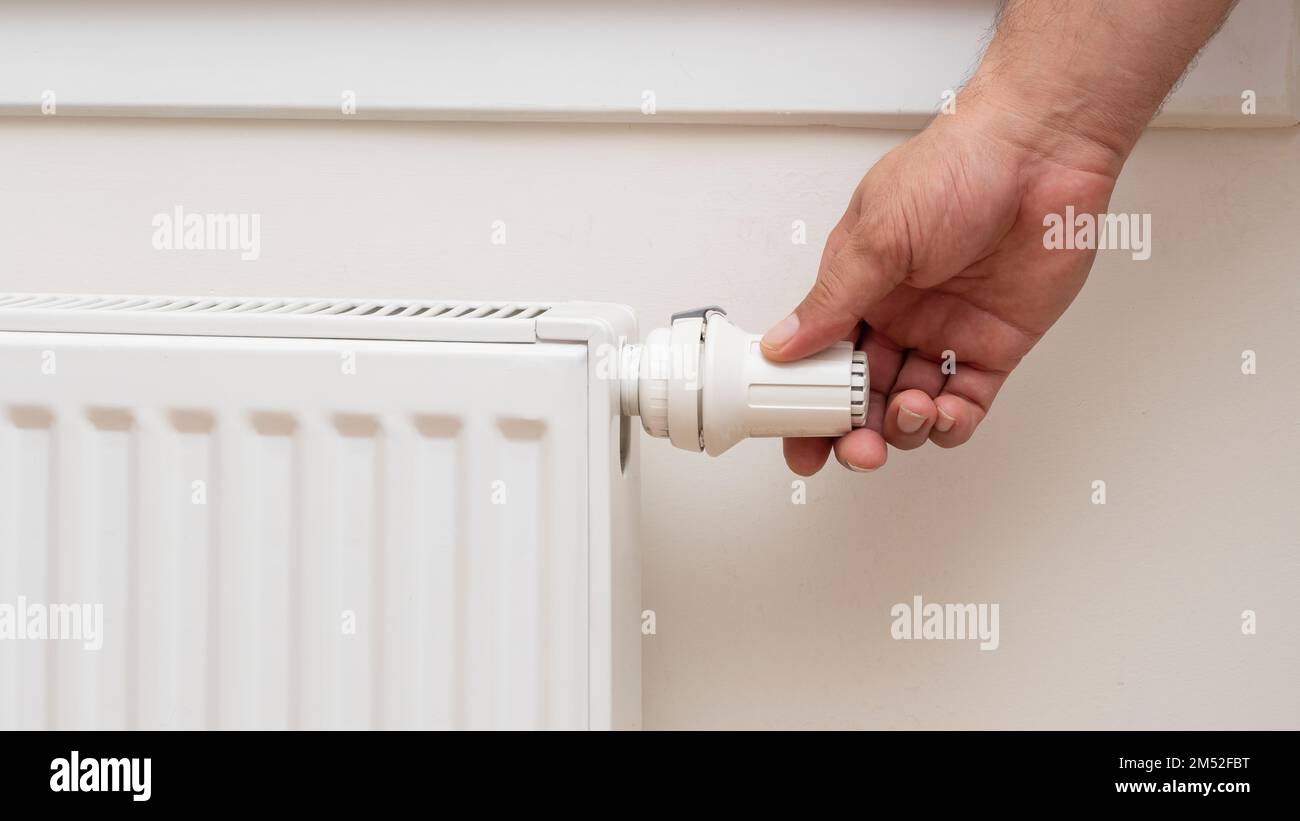 A human hand adjusting the temperature of a radiator Stock Photo - Alamy