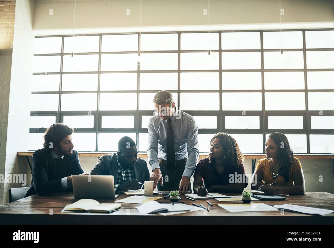 We dont work to be mediocre. a well-dressed businessman brainstorming ...