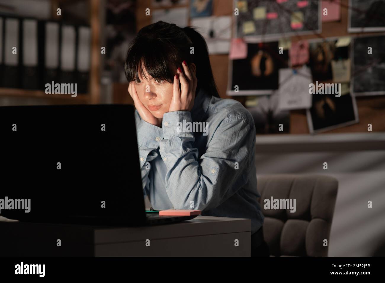 Frustrated detective in the office processing evidence, working using a ...