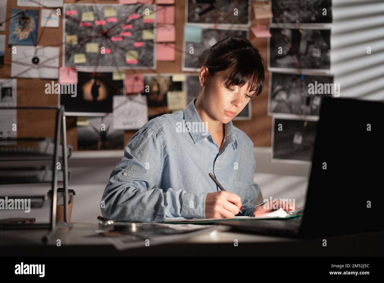Detective working at desk in her office using computer searching ...