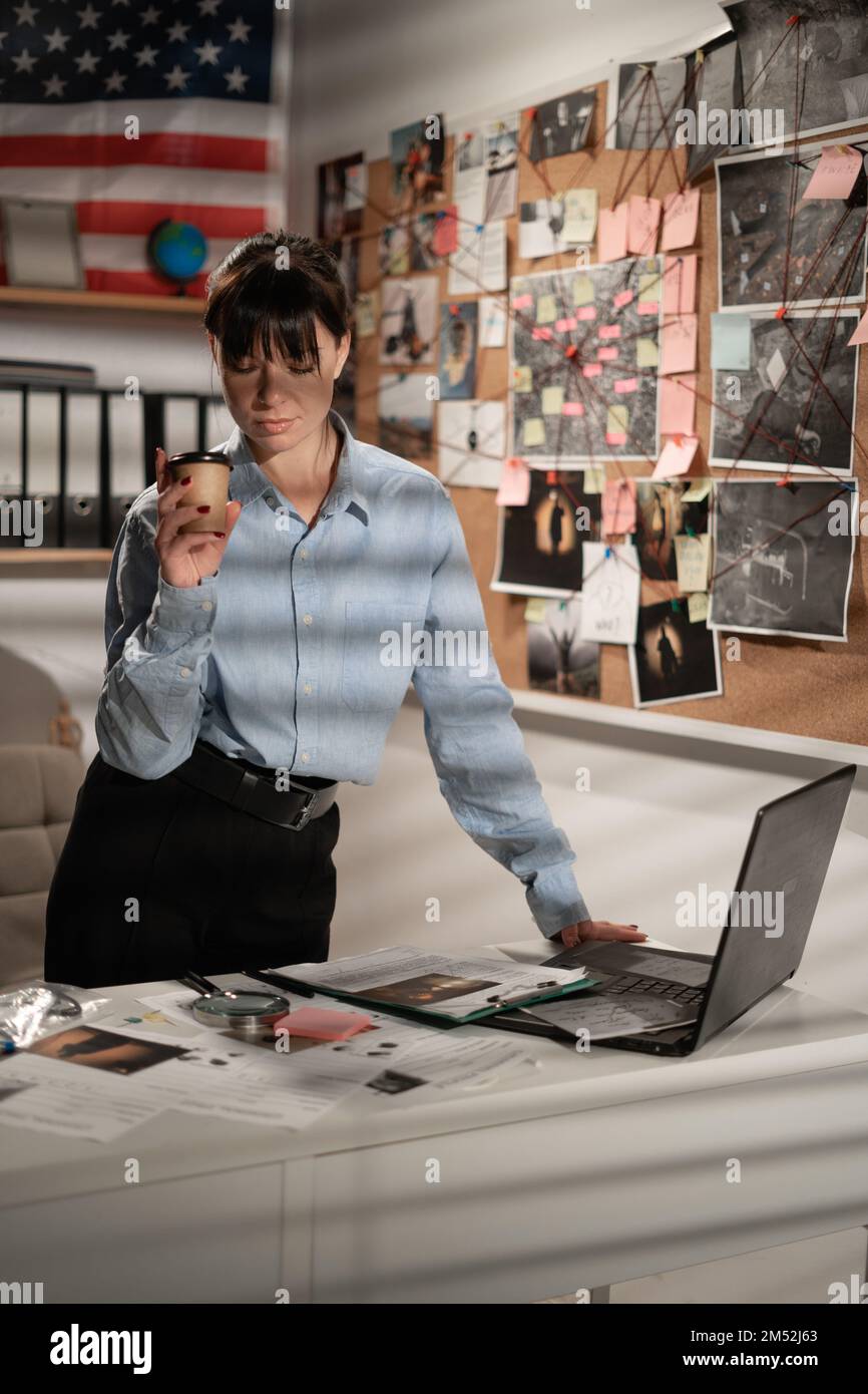 Detective working at desk in her office with cofee at night Stock Photo ...