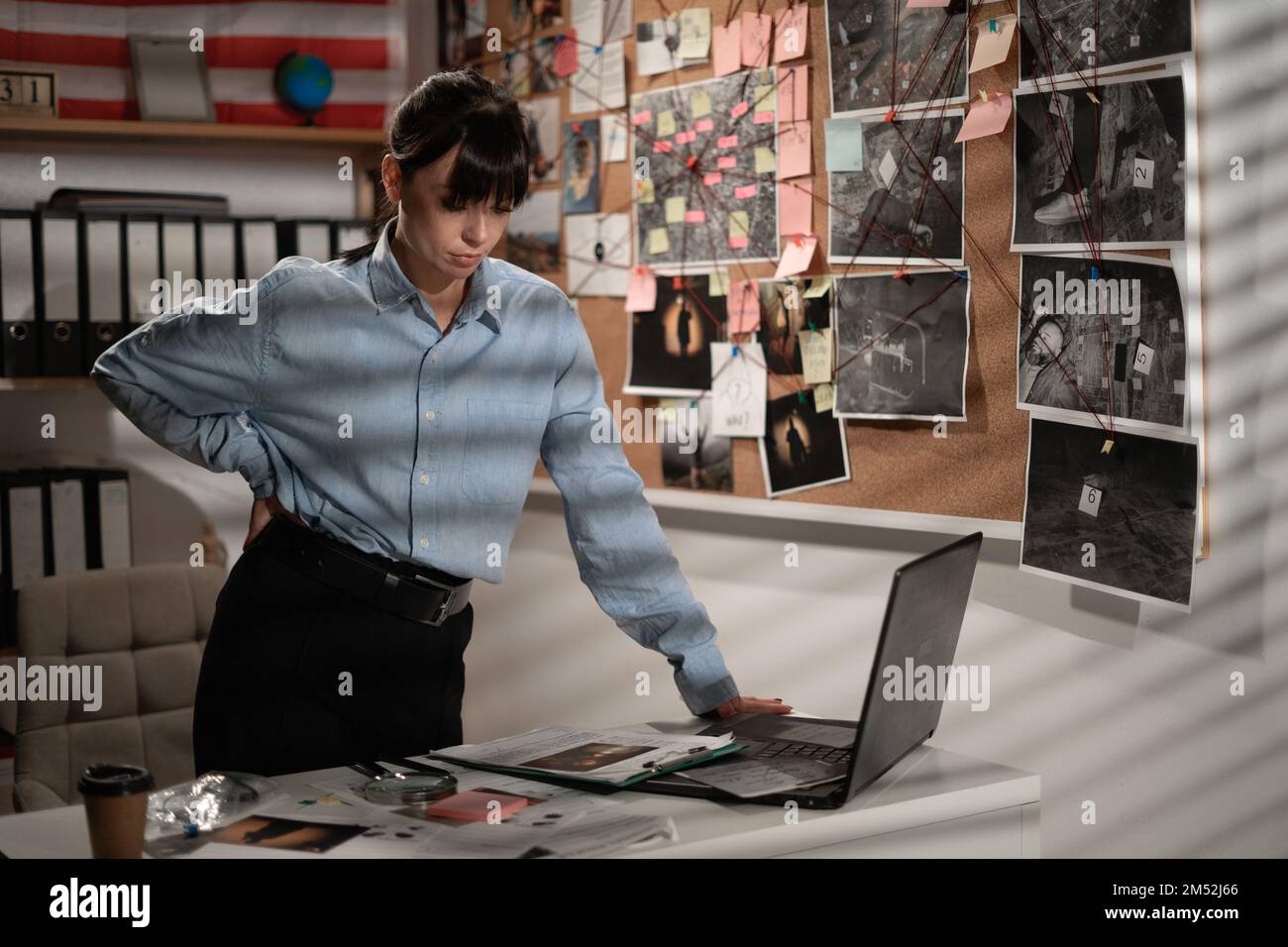 Detective working at desk with laptop computer in her office Stock ...