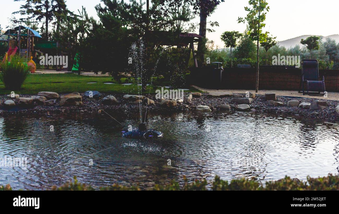 A decorative water fountain in a scenic park with walkways and sliders ...