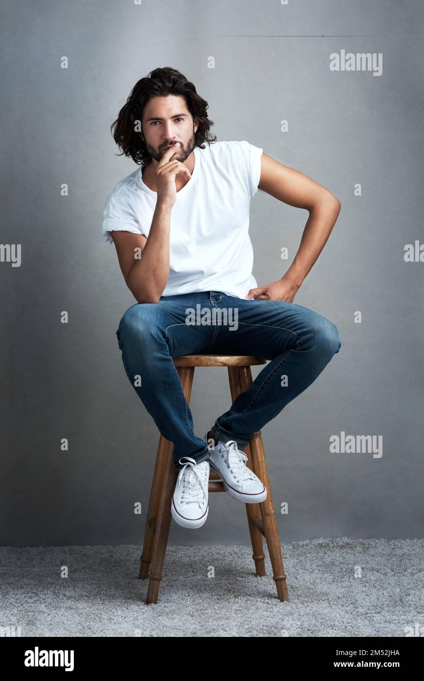 As handsome as ever. Studio shot of a handsome young man sitting on a ...