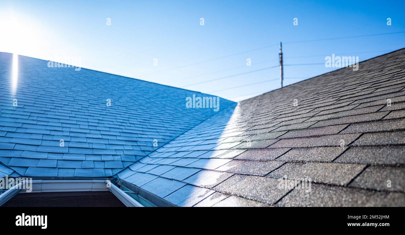 Contrast of frost line on a shingle roof as the sun rises and melts it ...