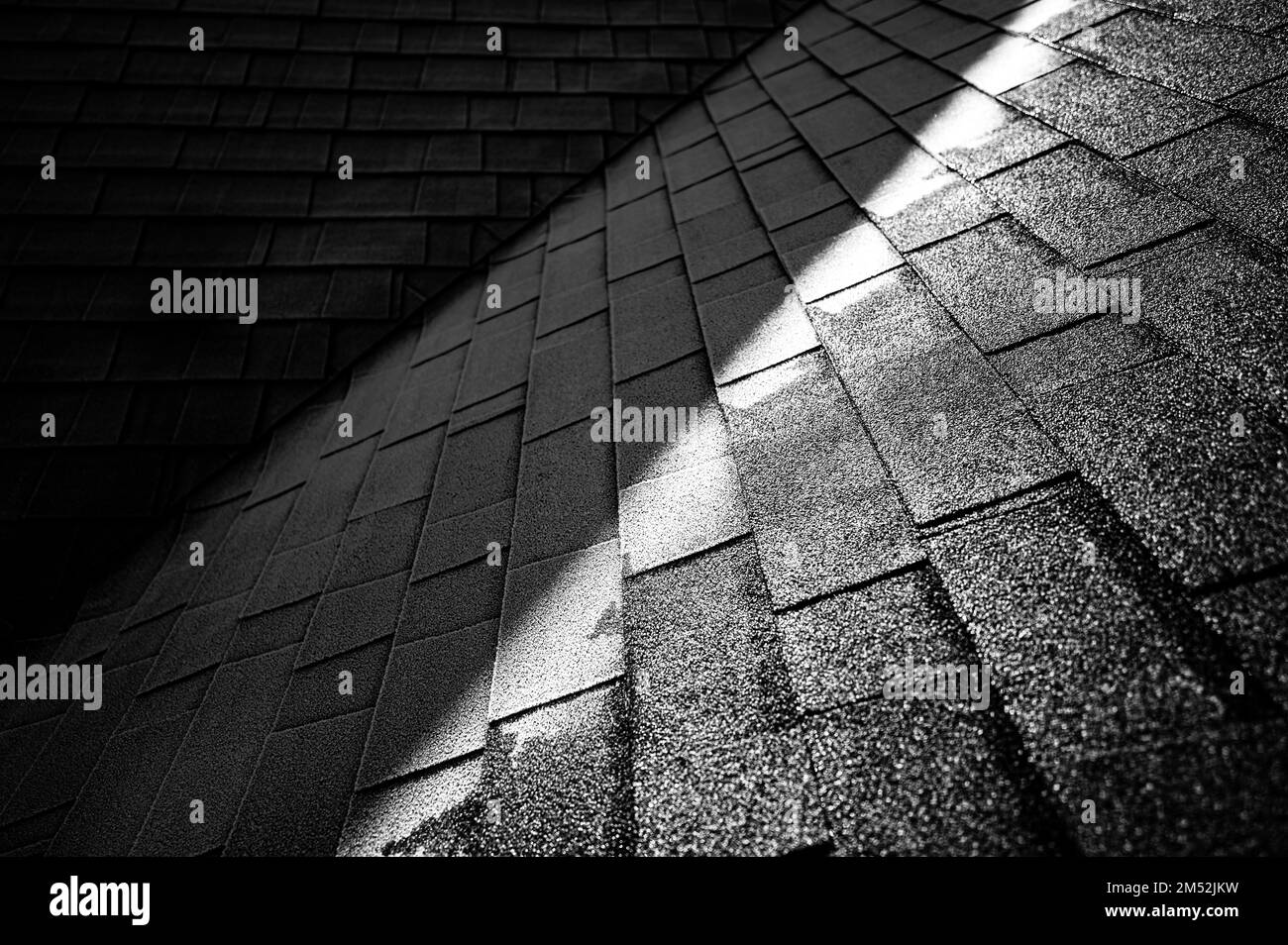 Contrast of frost line on a shingle roof as the sun rises and melts it ...