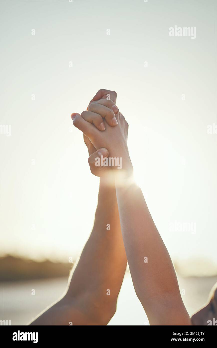 There is strength in unity. a couple holding hands and arms raised ...