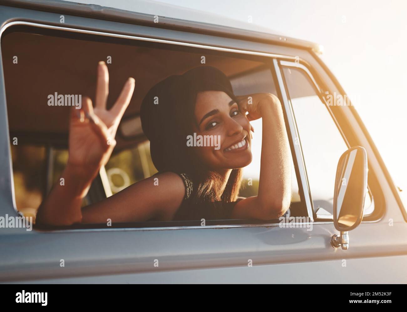 Less winter, more summer. a young woman leaning out of a vans window ...