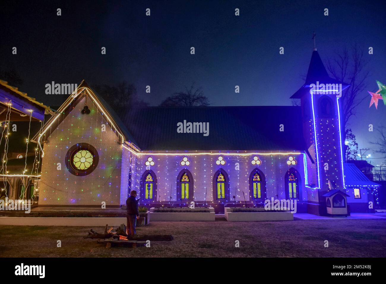 A security guard warms himself in font of the bonfire outside the Holy ...