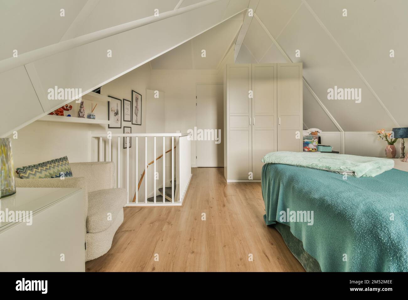 a bed in a room with white walls and wood flooring on the bottom half ...