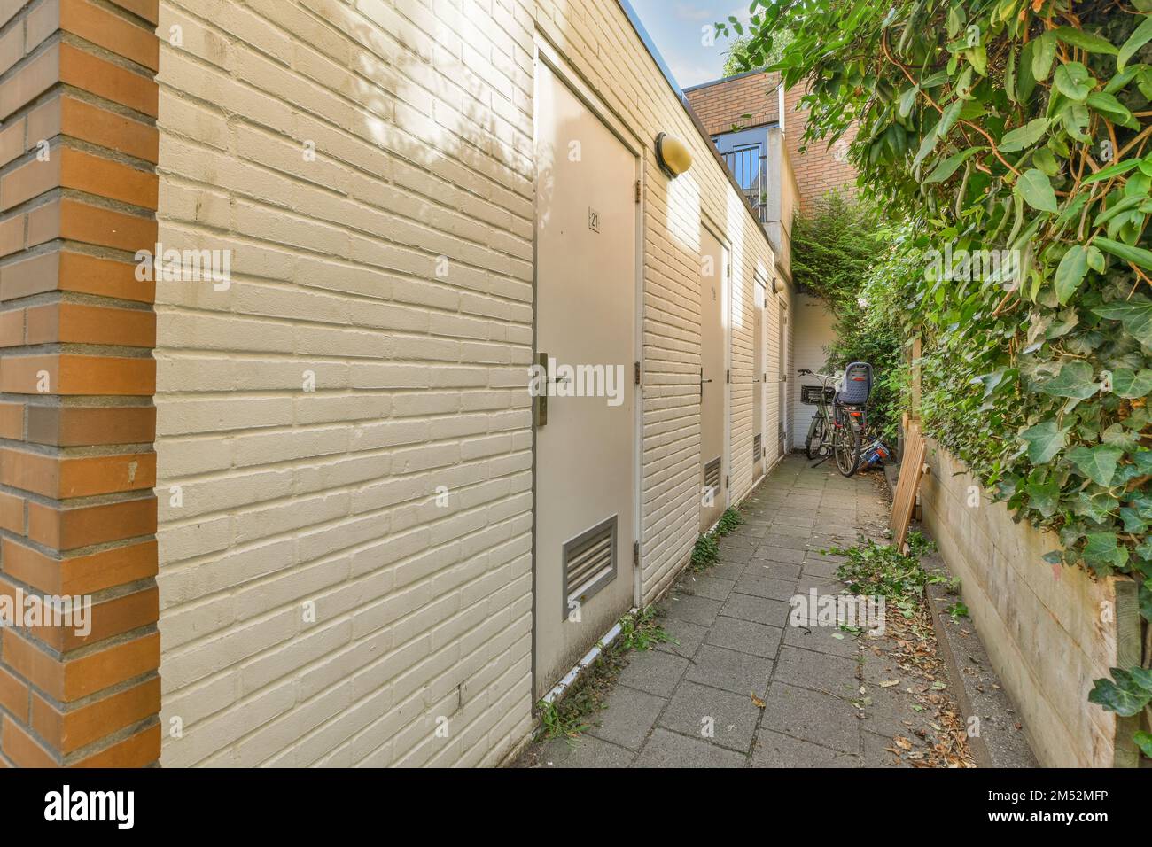 an alley in the city with trees and plants on either side of buildings ...