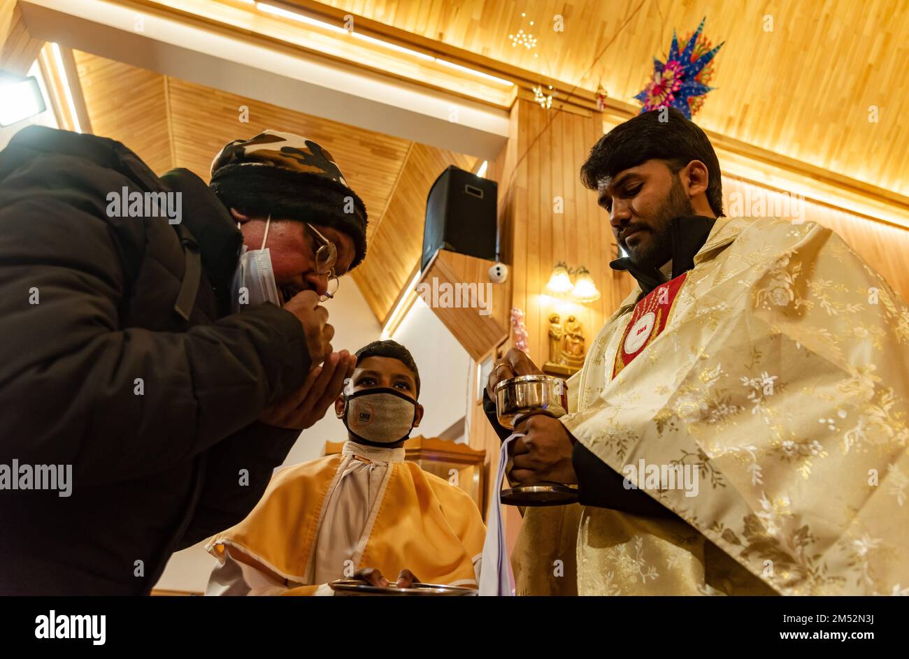 Catholic priest is seen giving holy communion inside a church during ...