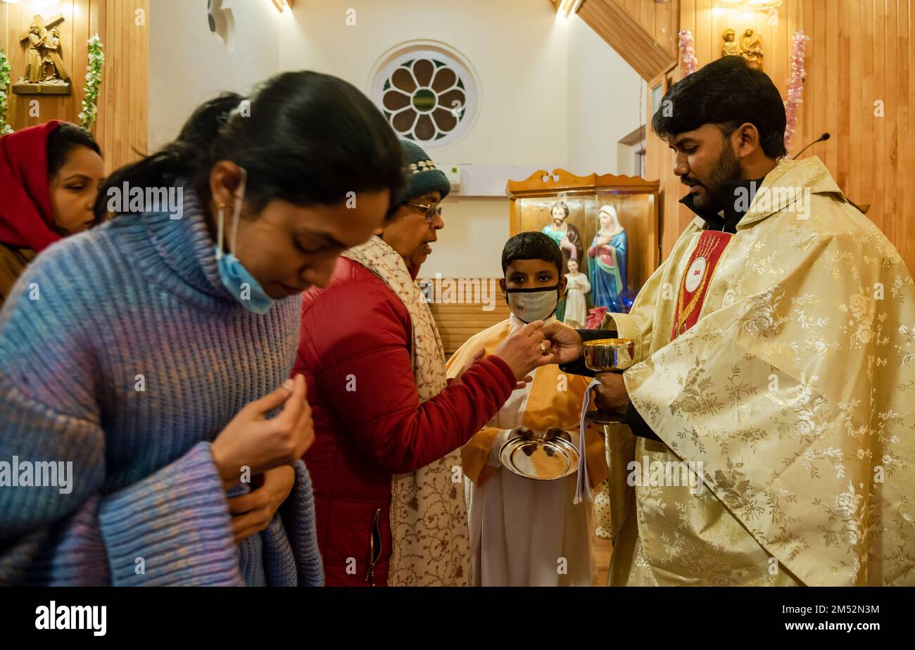 Catholic priest is seen giving holy communion inside a church during ...