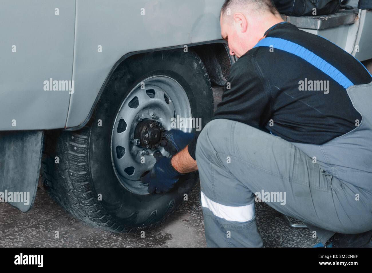 Man changes wheel of car in car service. Professional auto mechanic in ...