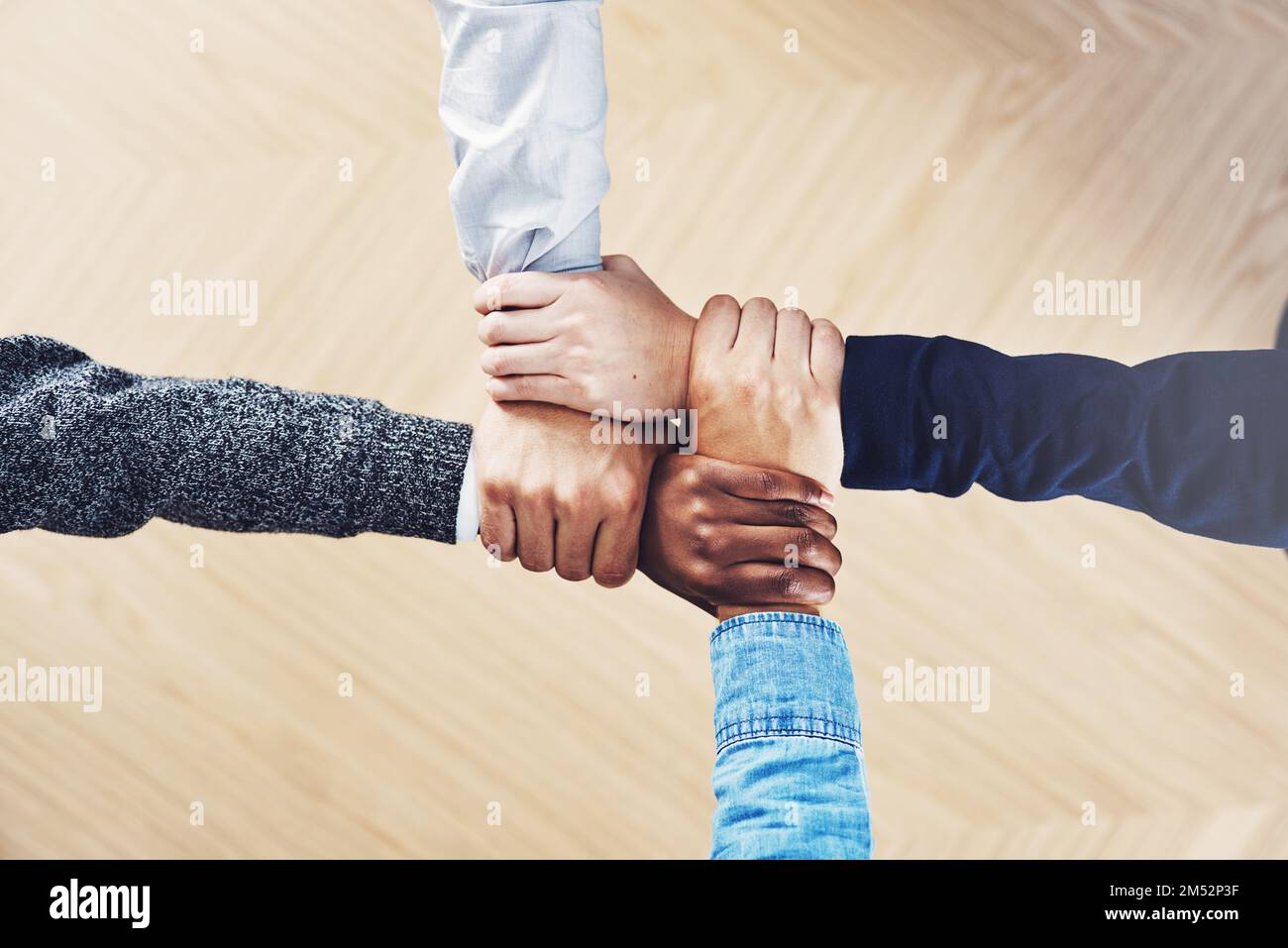 We are one. a group of businesspeople linking their arms in solidarity ...