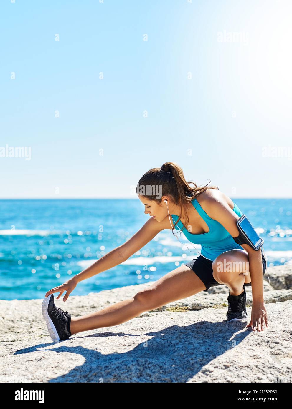 Getting ready for action. a young woman stretching before her run Stock ...