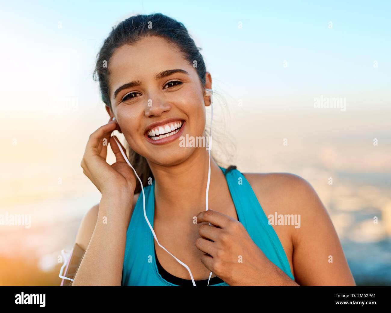 My playlist is never dull. Cropped portrait of a young woman listening ...