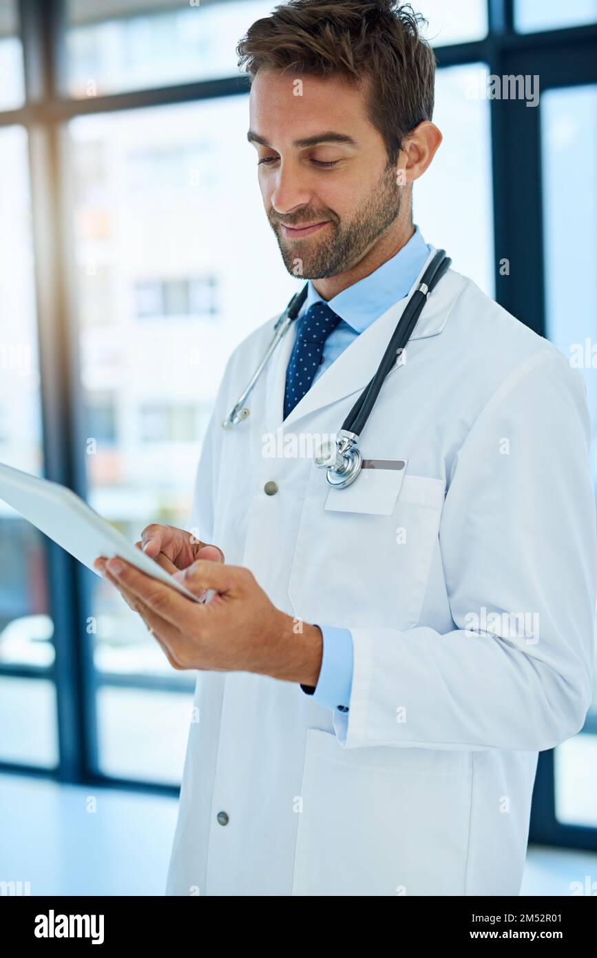 Now he has all his patient files in one place. a busy doctor checking a ...