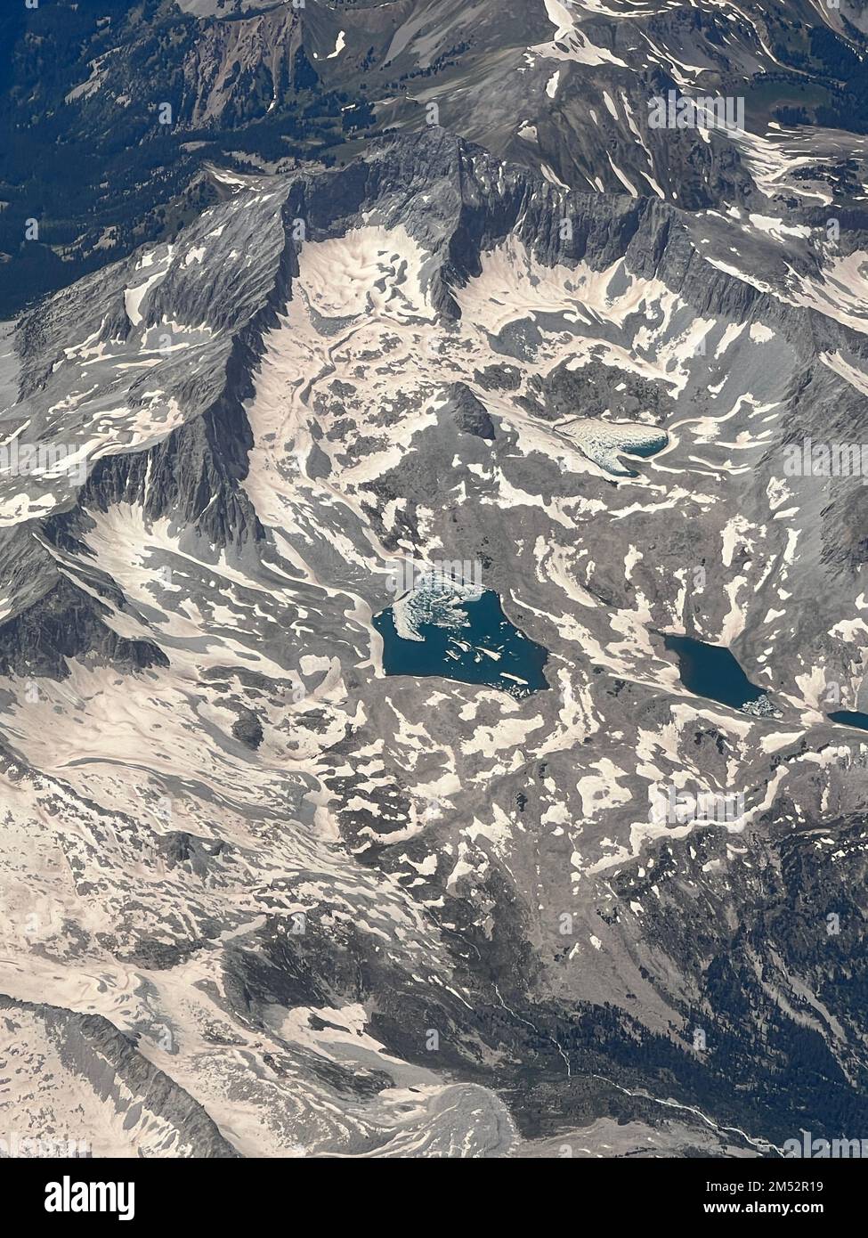 A vertical aerial view of a rural landscape with rocky hills and a body ...