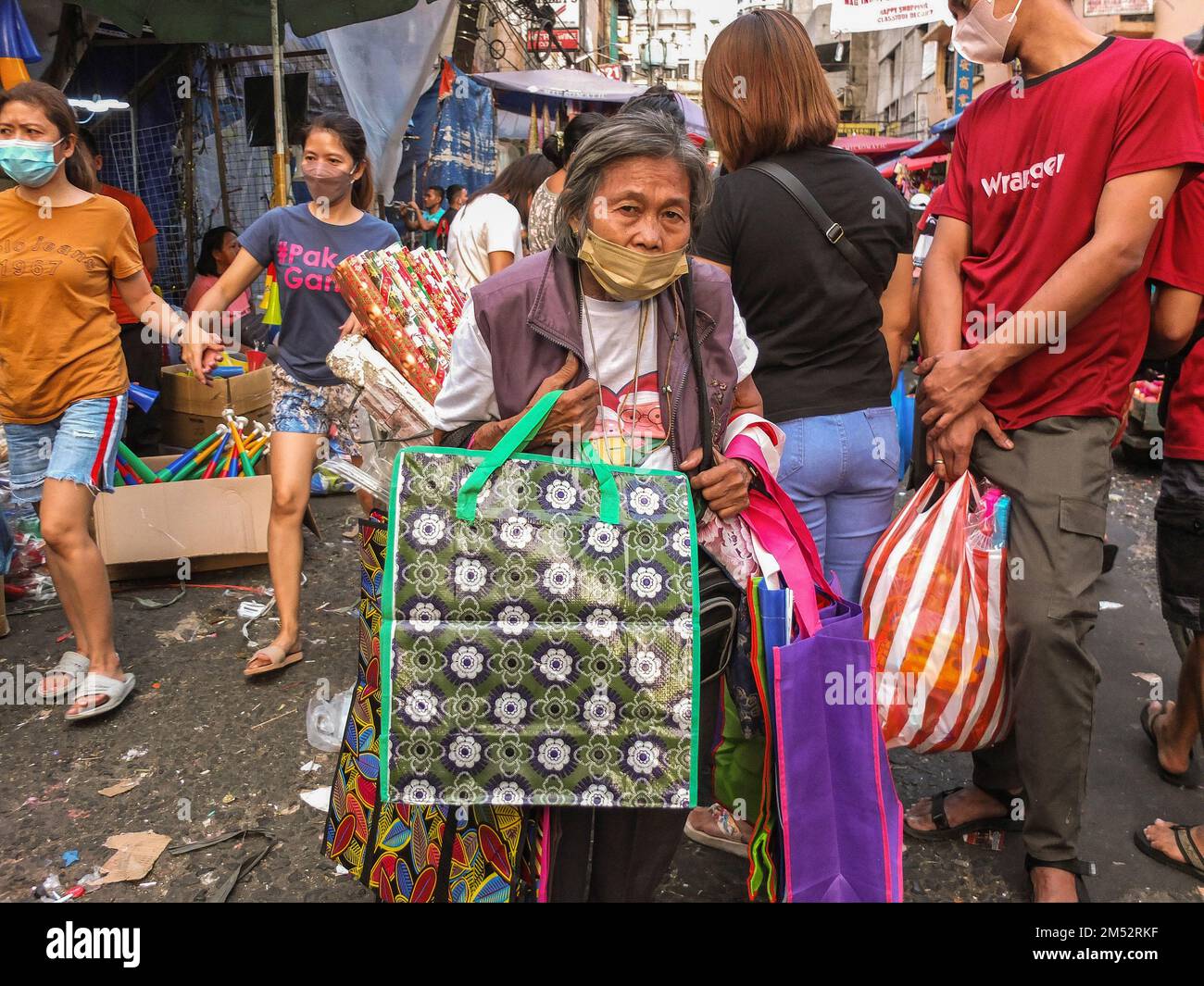 A vendor has seen carrying her merchandise, gift wrappers, and shopping ...