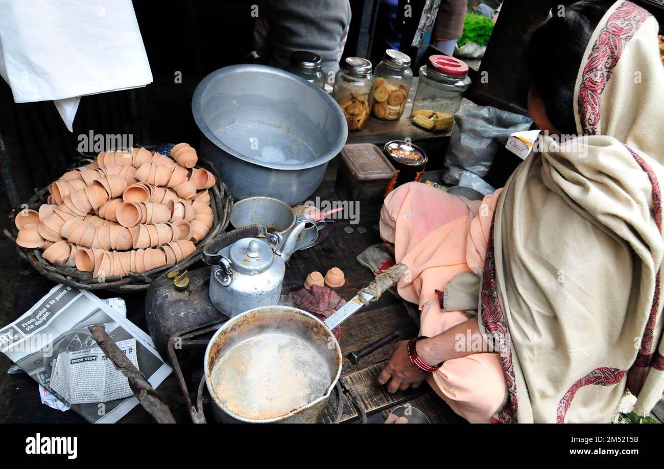 A Bengali woman preparing traditional Indian milk tea in Kolkata, India ...