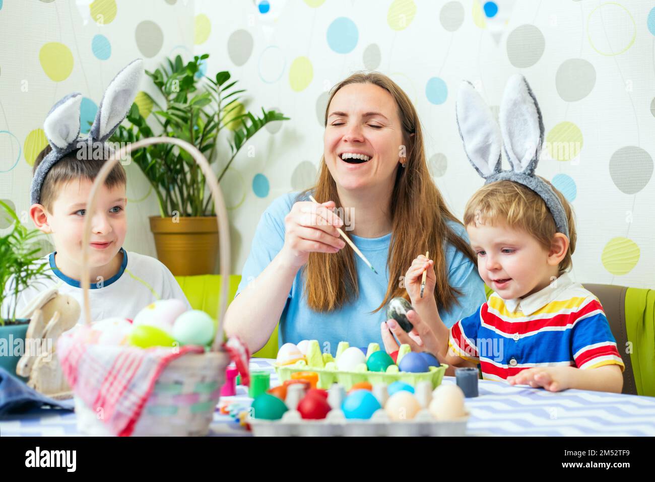 Happy Easter. A mother and her children painting Easter eggs Stock ...