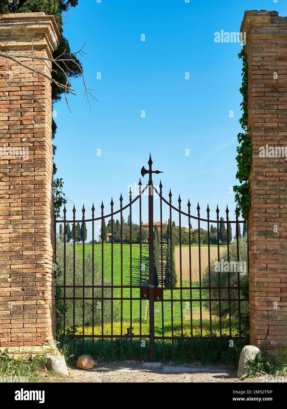 View on a typical Tuscan farmhouse through vintage gate Stock Photo - Alamy