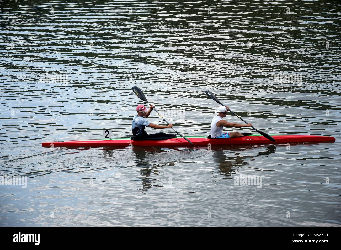 Two athletes are sailing canoe on river, controlling oars. Active ...