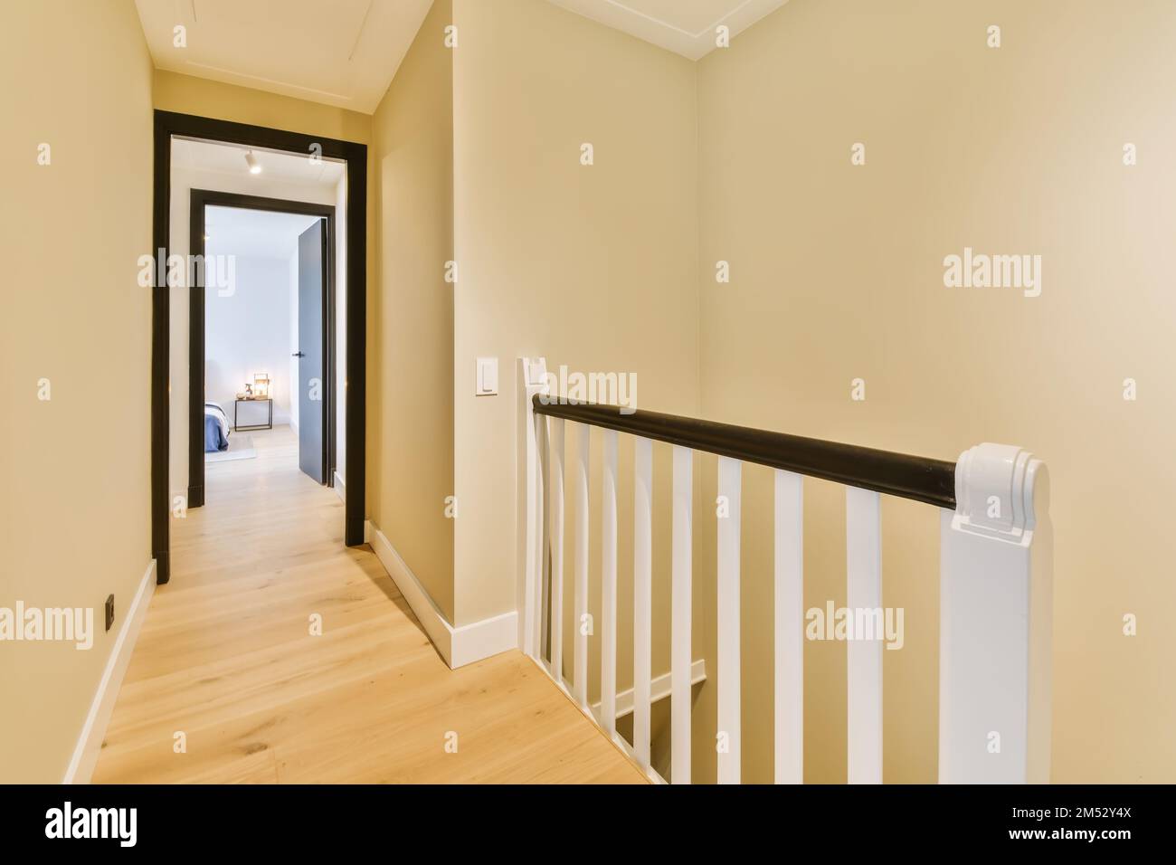 a hallway with wooden flooring and white railings on the staircase ...
