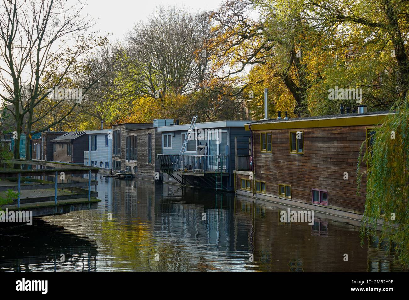 The floating houses in the canals of Amsterdam in the Netherlands with ...