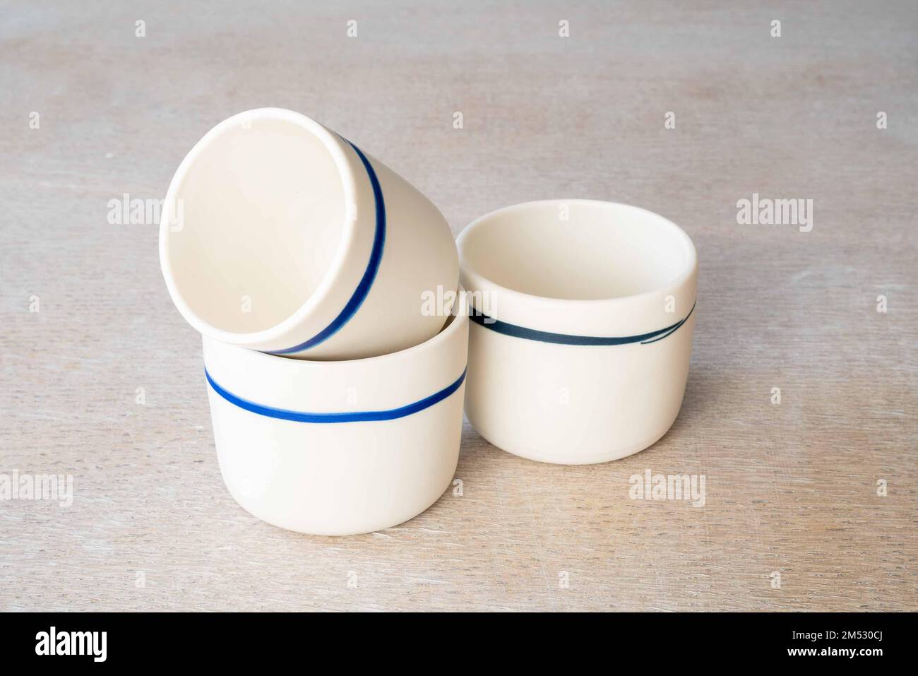 Different sizes of luxury white and brown ceramic dipped mugs on marble ...