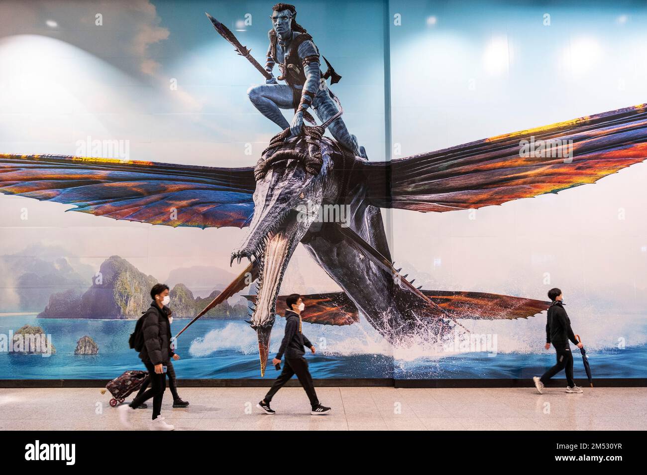 Hong Kong, China. 24th Dec, 2022. Commuters walk past a large ...