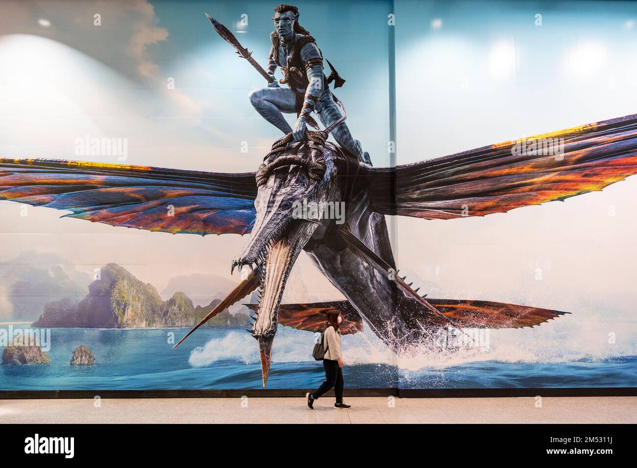 Commuter walks past a large commercial advertisement banner promoting ...