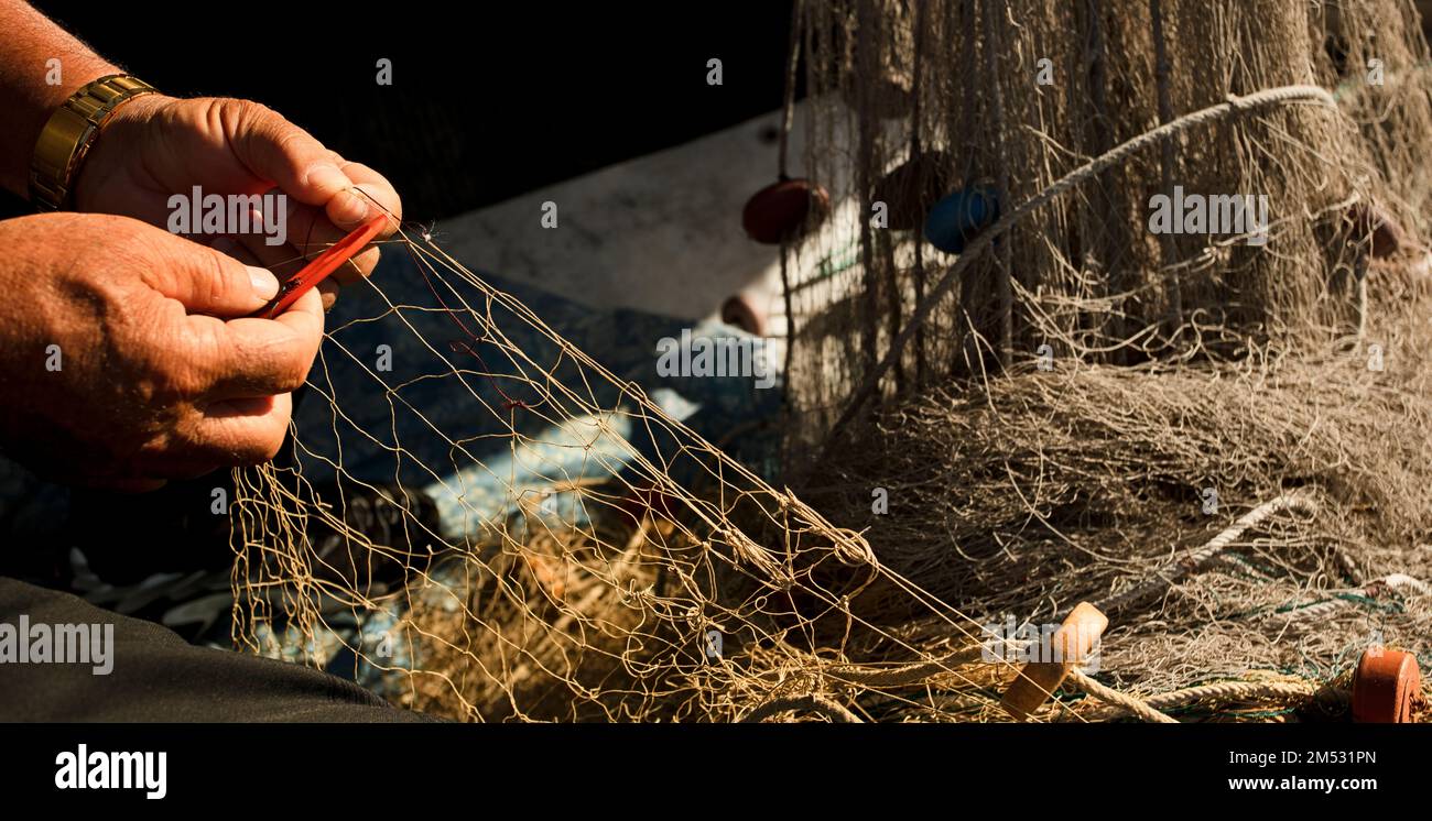 fishing net in the hands of fisherman, with needle and thread, grabs ...