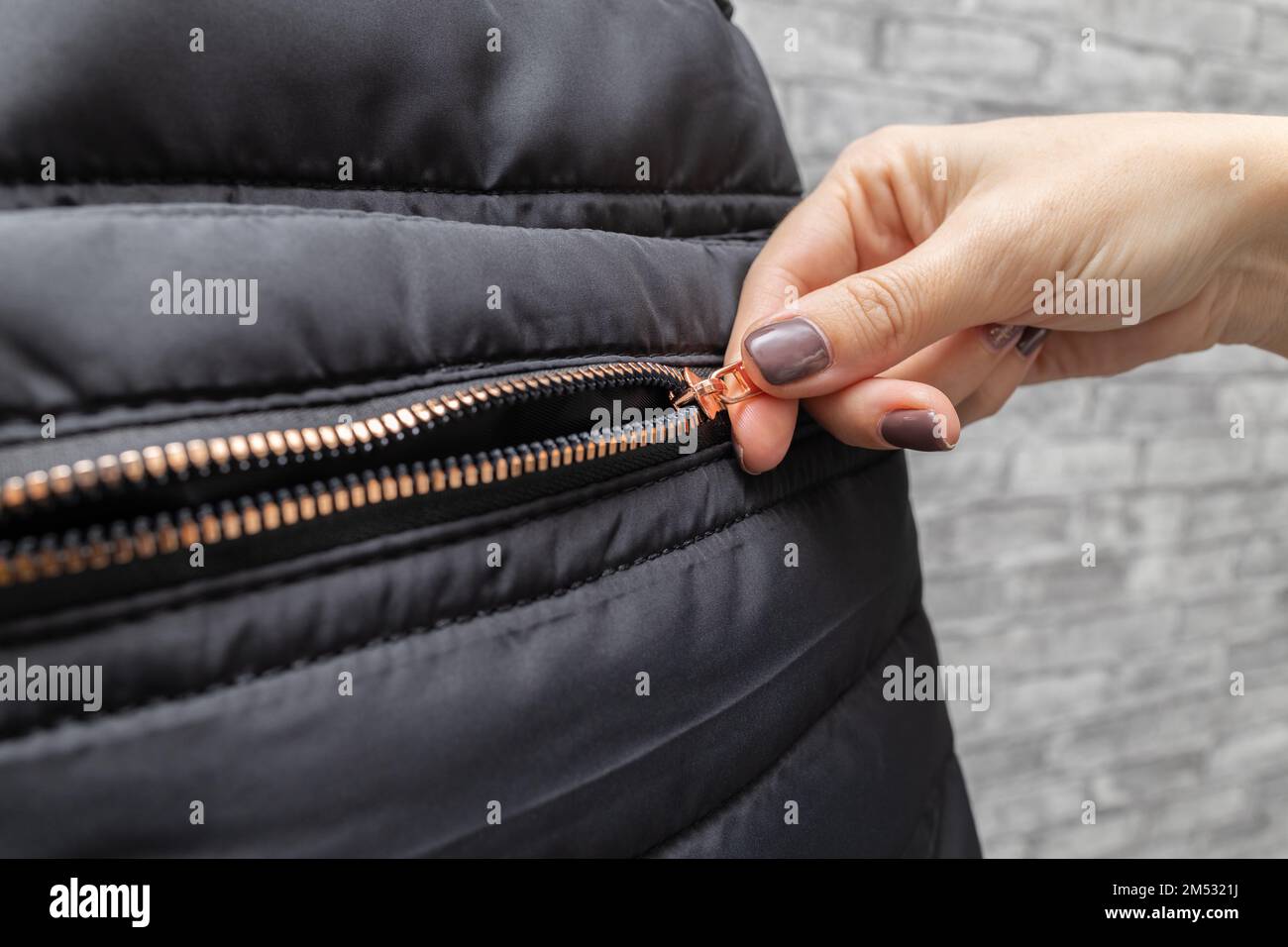 woman opens a zipper lock with her hand. man unzips a zipper. hand ...