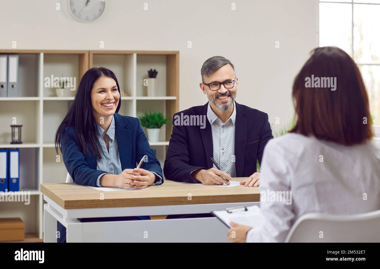 Smiling, friendly businesswoman with its business partner conducts ...