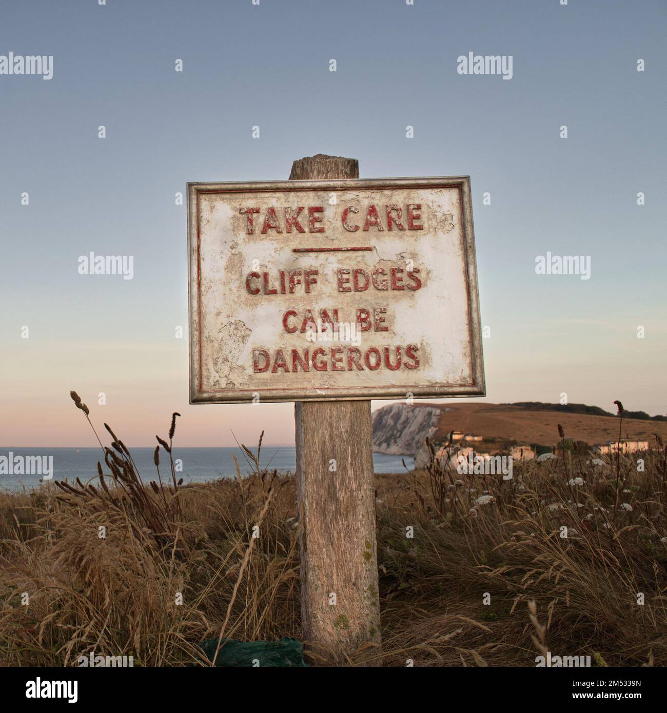 A warning sign about dangerous cliff edges Stock Photo - Alamy