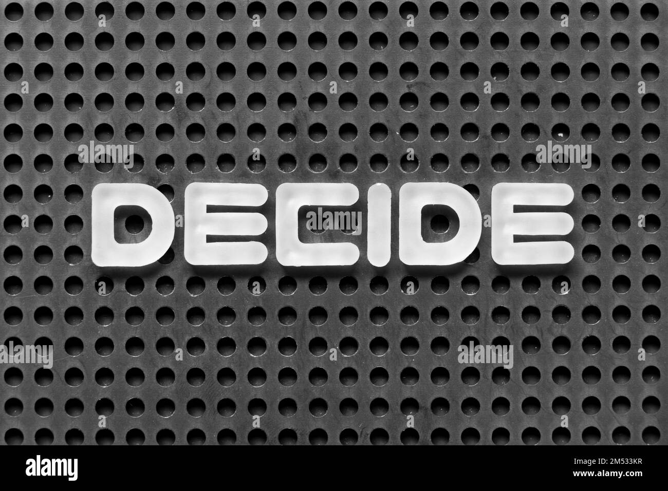 White alphabet letter in word decide on black pegboard background Stock ...