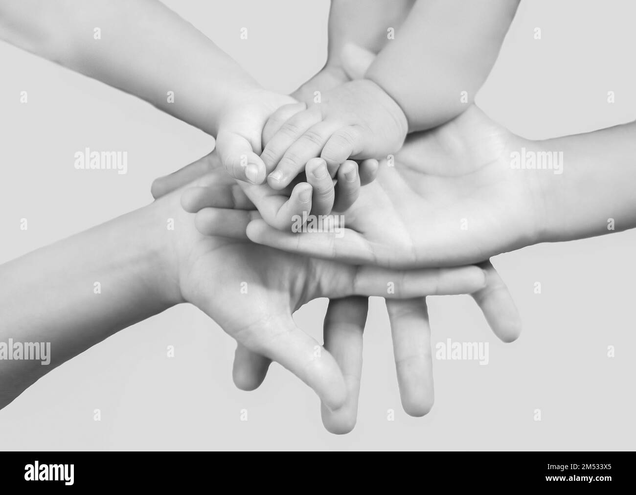 A grayscale of family members holding hands Stock Photo - Alamy