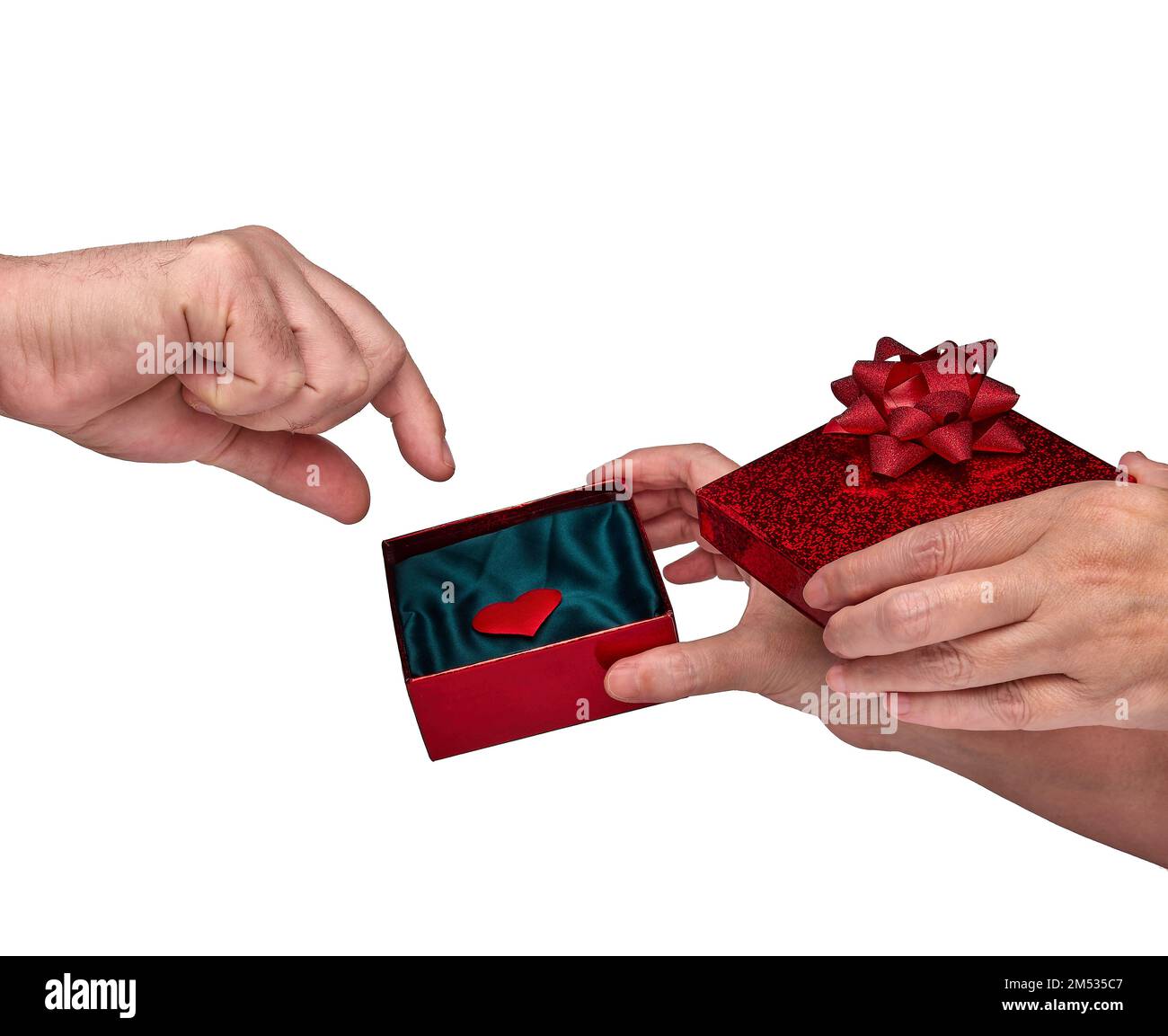 Hand of a man, taking a red heart out of a gift box, held by a woman ...