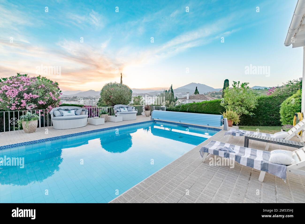 a garden image full with deck chairs and a swimming pool along the ...