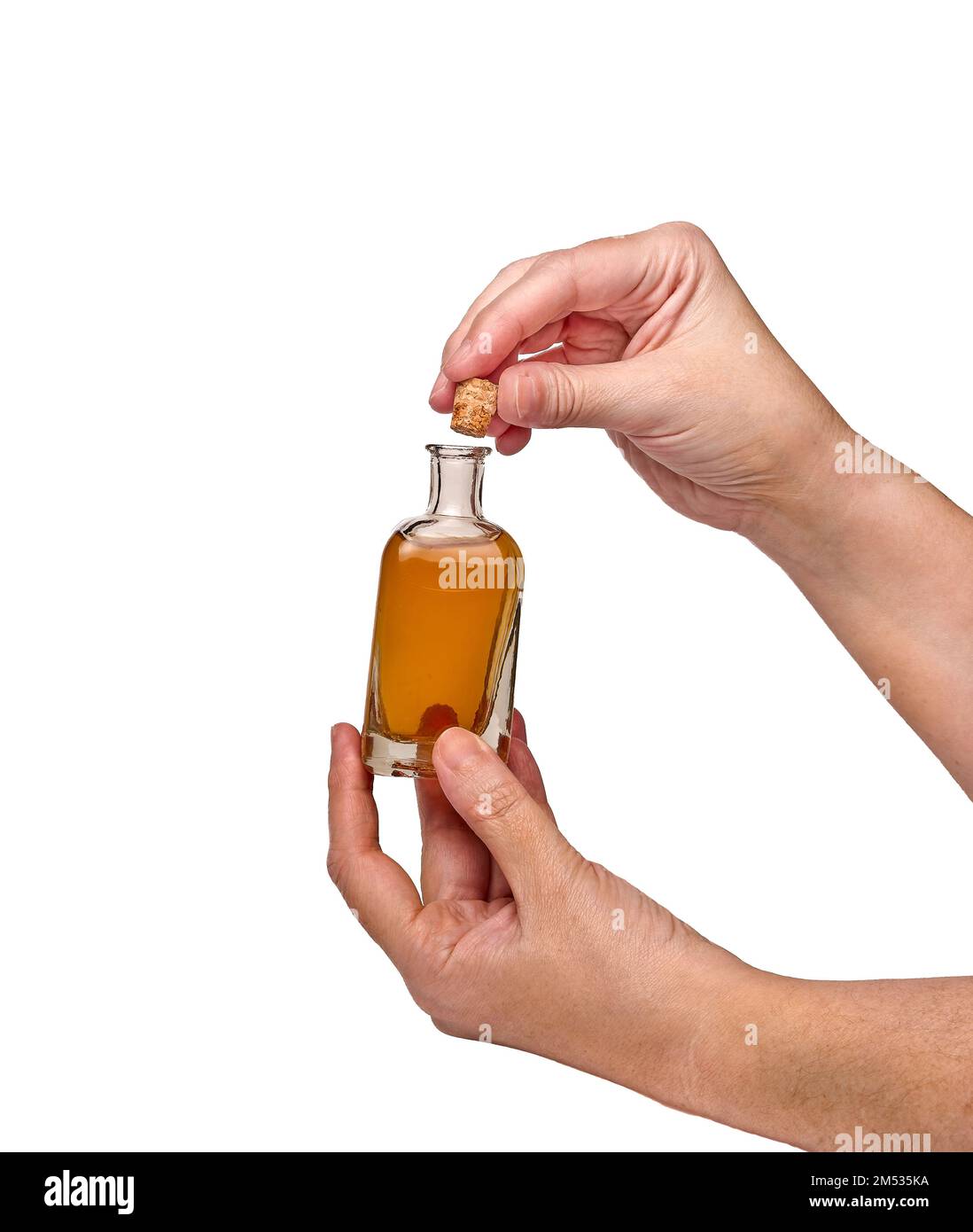 Woman hands holding small glass bottle, with yellow liquid, isolated on ...