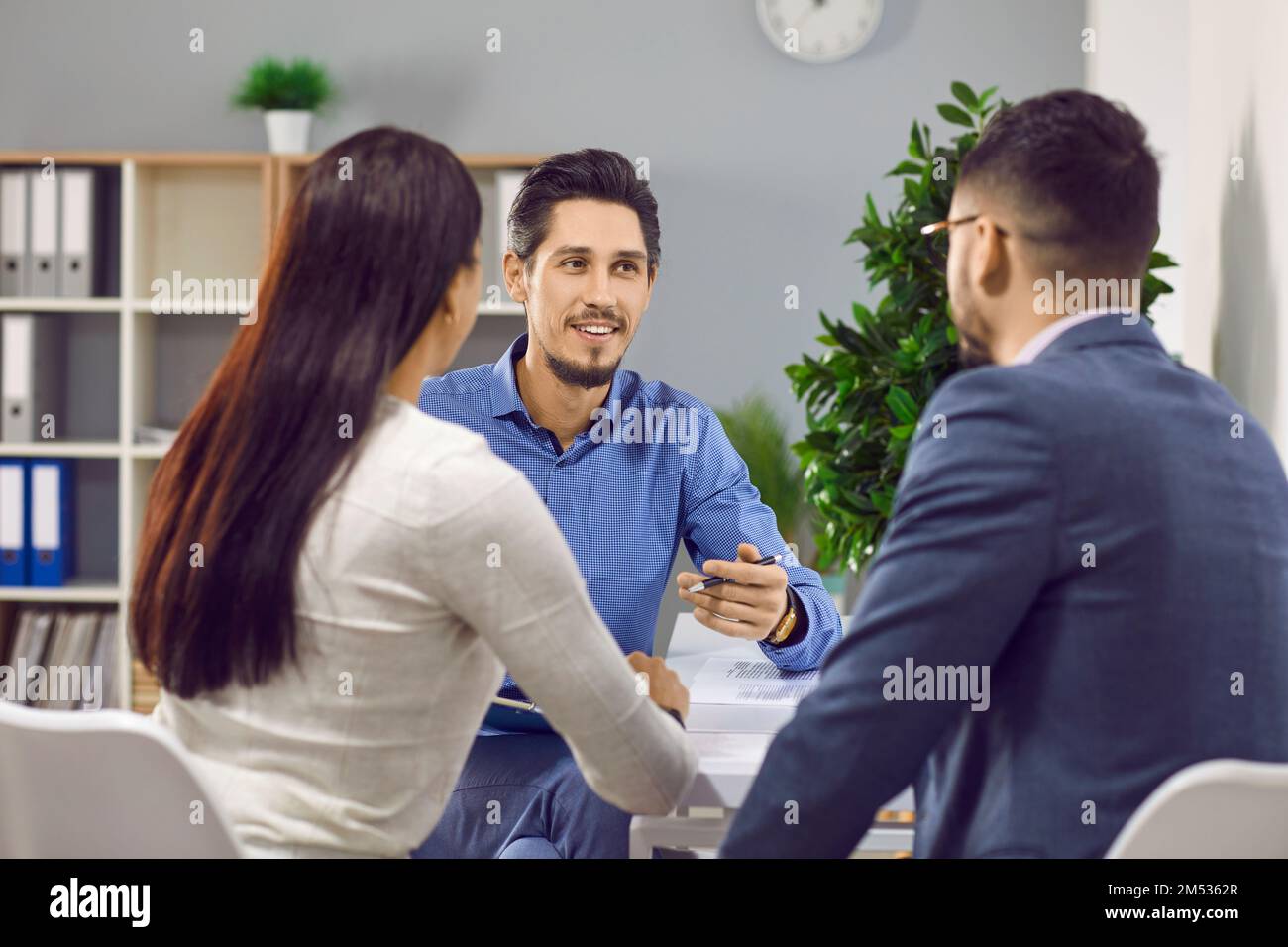 Happy family couple signing contract together in office Stock Photo - Alamy