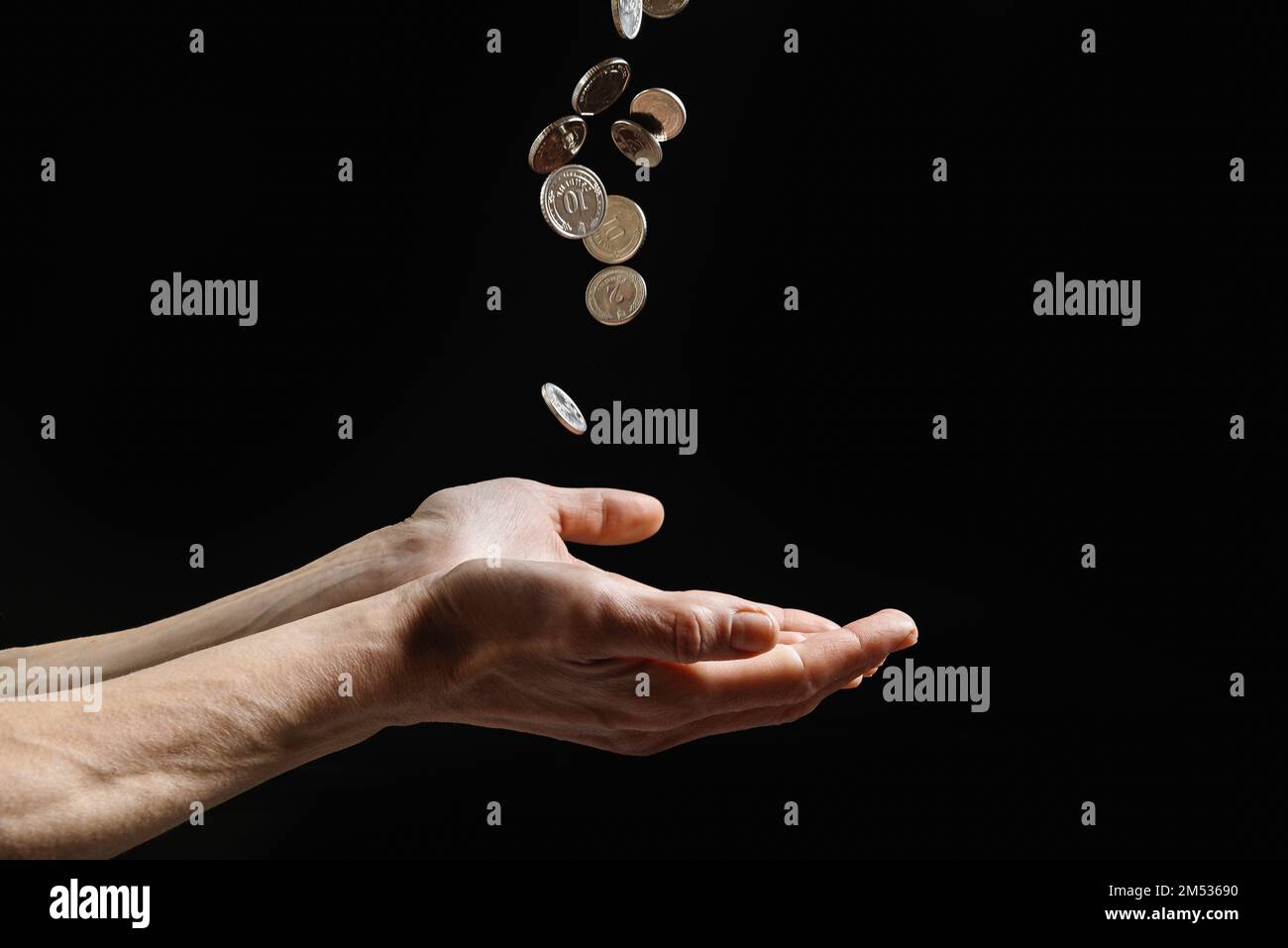 Coins fall into the hands of a poor man. Financial aid on dark ...