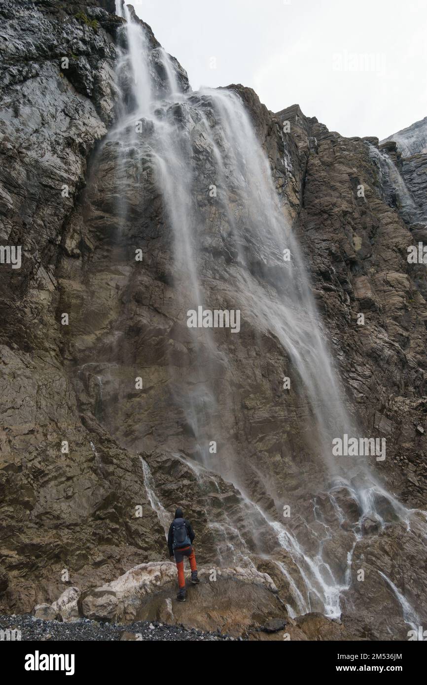 Cirque de Gavarnie with big waterfall and small person at massive high ...