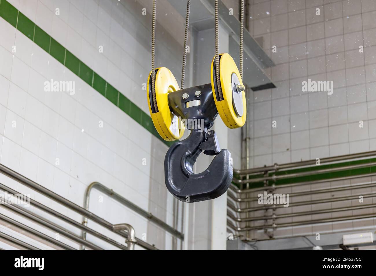 hook of an overhead crane with suspended dust illuminated by the ...