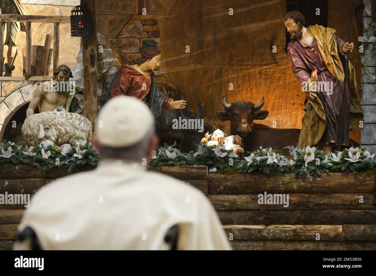 Pope Francis, in a wheel chair, looks at the crib after the celebration ...